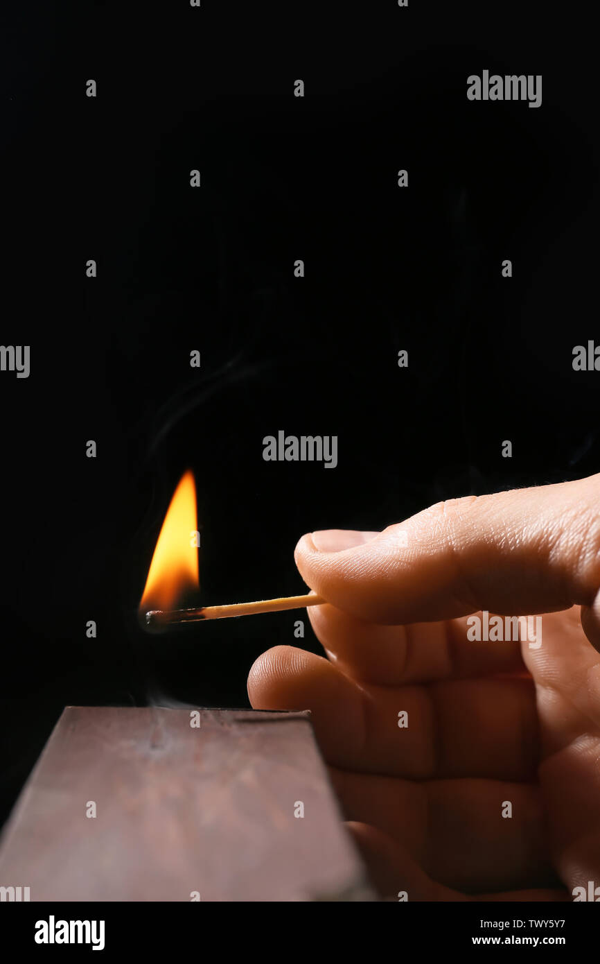 Man striking match on dark background Stock Photo - Alamy
