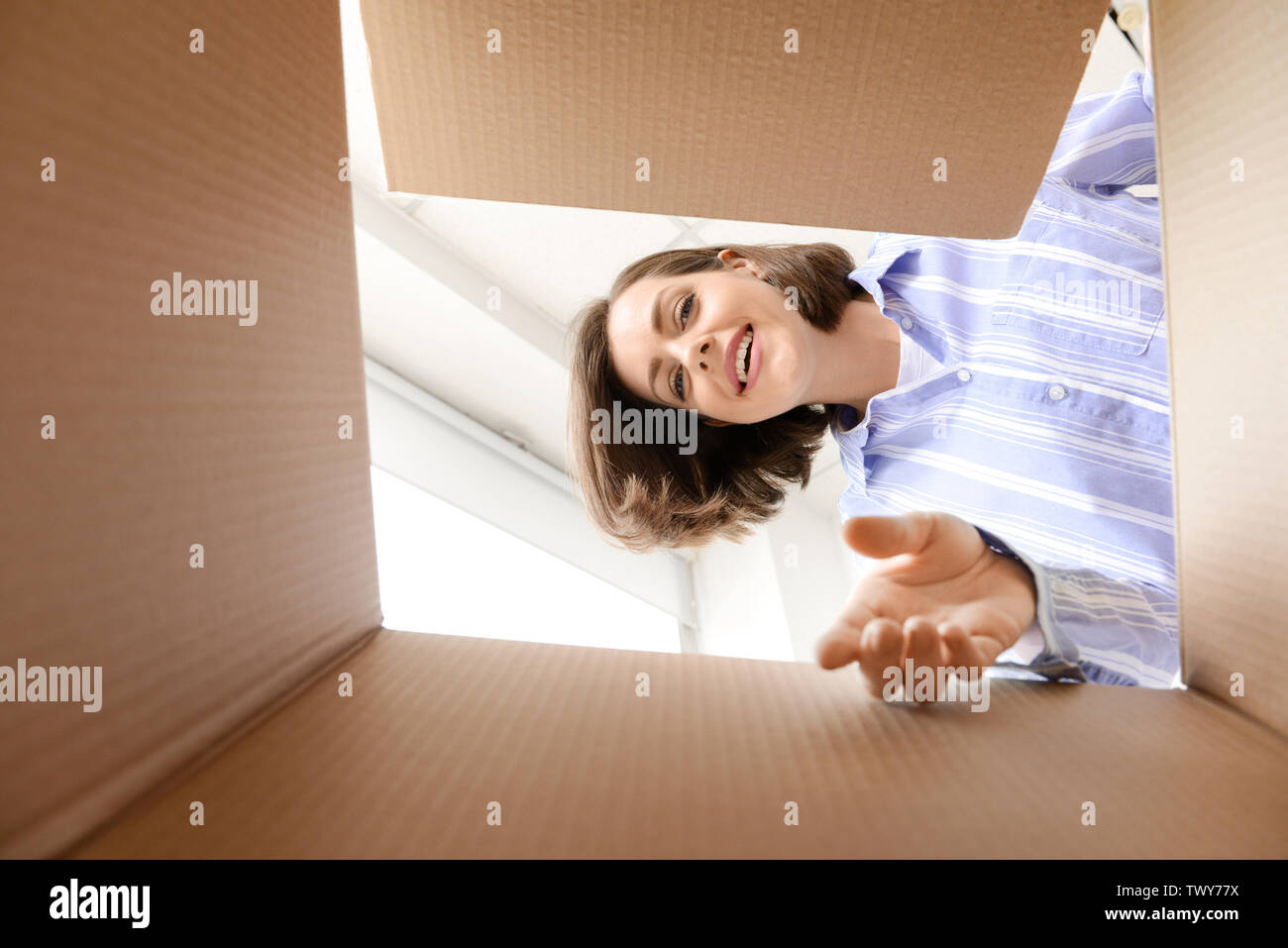 Young woman opening parcel at home, view from inside of box Stock Photo ...
