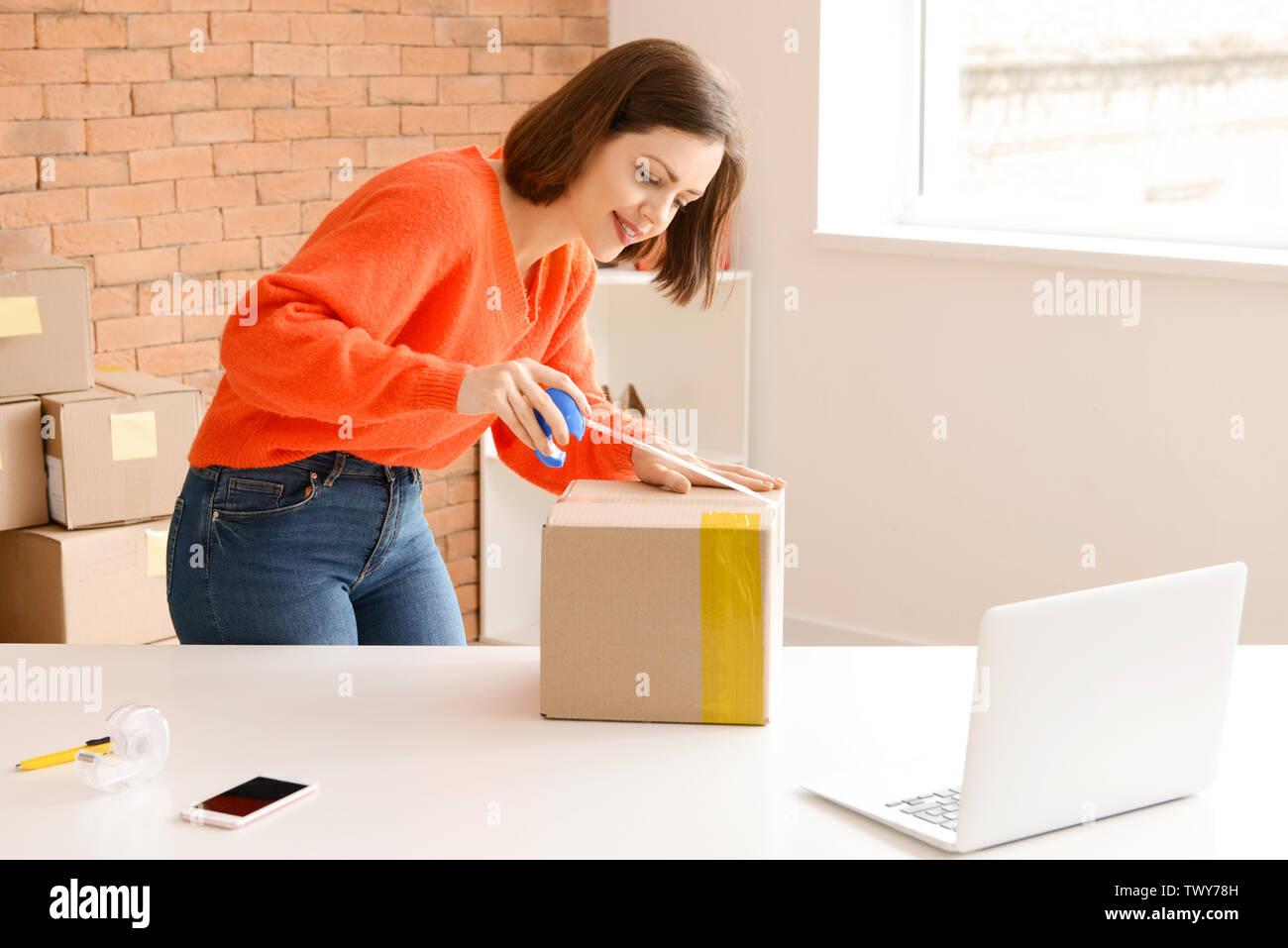 Young woman packing box indoors Stock Photo - Alamy