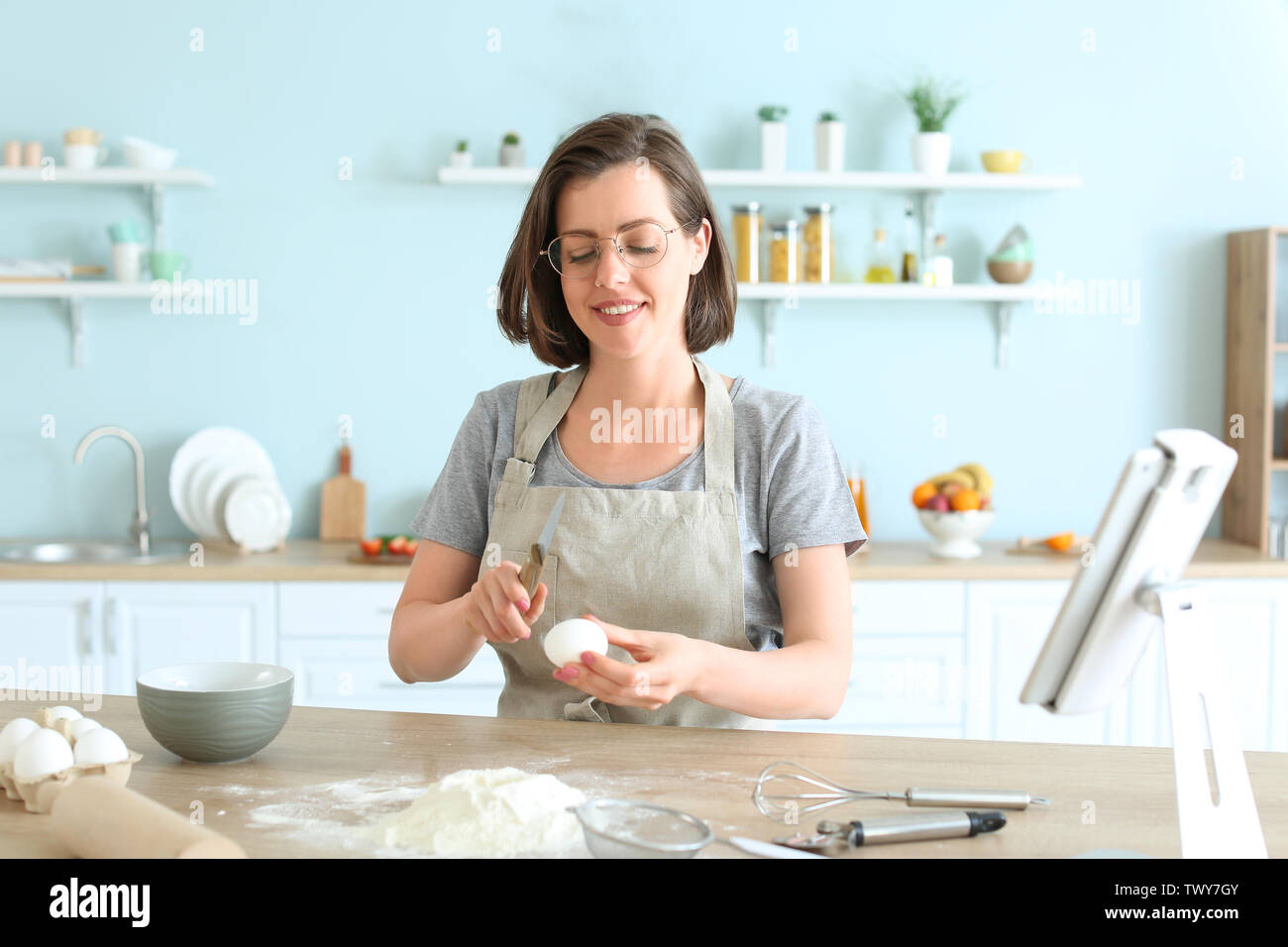 Beautiful young woman cooking pastry in kitchen Stock Photo - Alamy