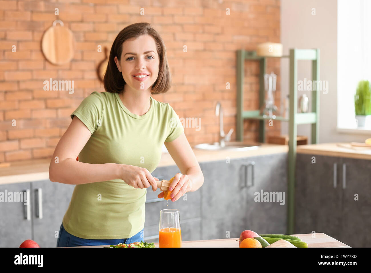 Beautiful young woman making breakfast in kitchen Stock Photo - Alamy