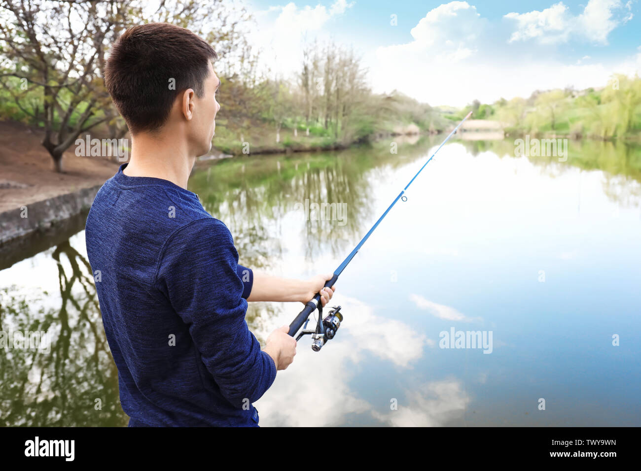 Young man fishing riverside hi-res stock photography and images - Alamy