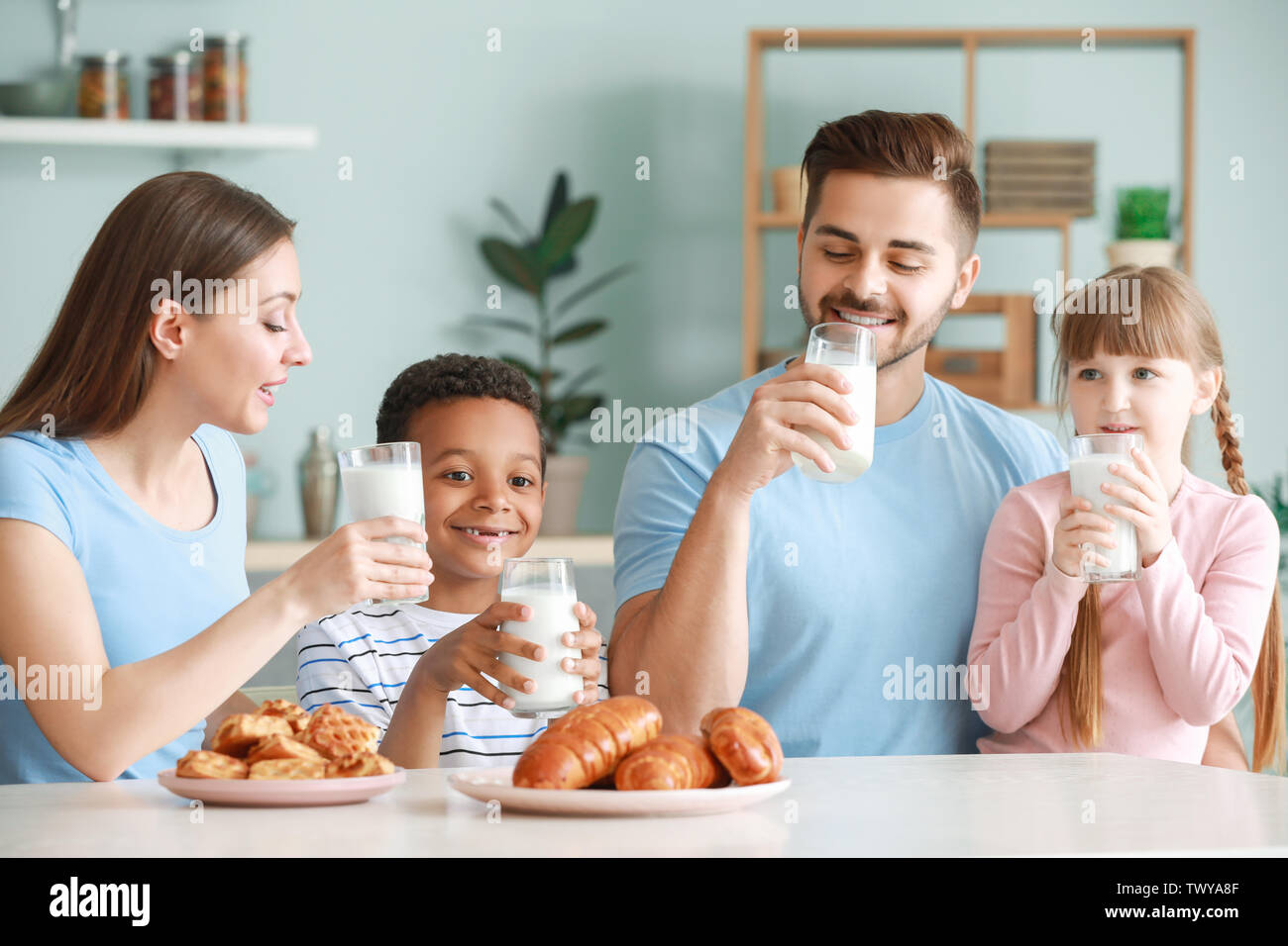 Young family drinking tasty milk in kitchen at home Stock Photo - Alamy