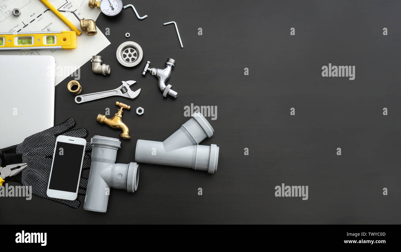 Mobile phone with plumbing items on dark background Stock Photo - Alamy