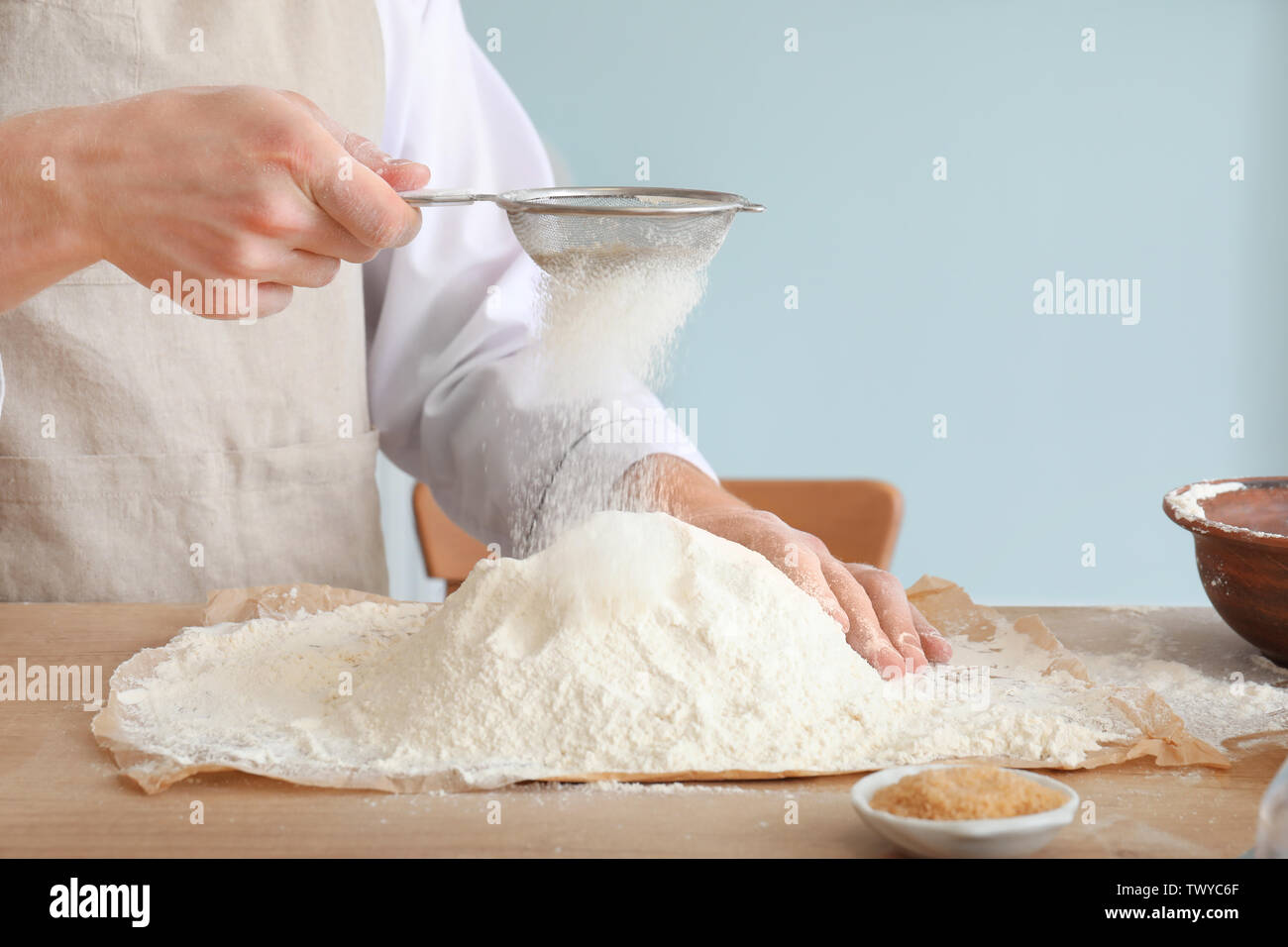 Male chef sieving flour in kitchen Stock Photo - Alamy