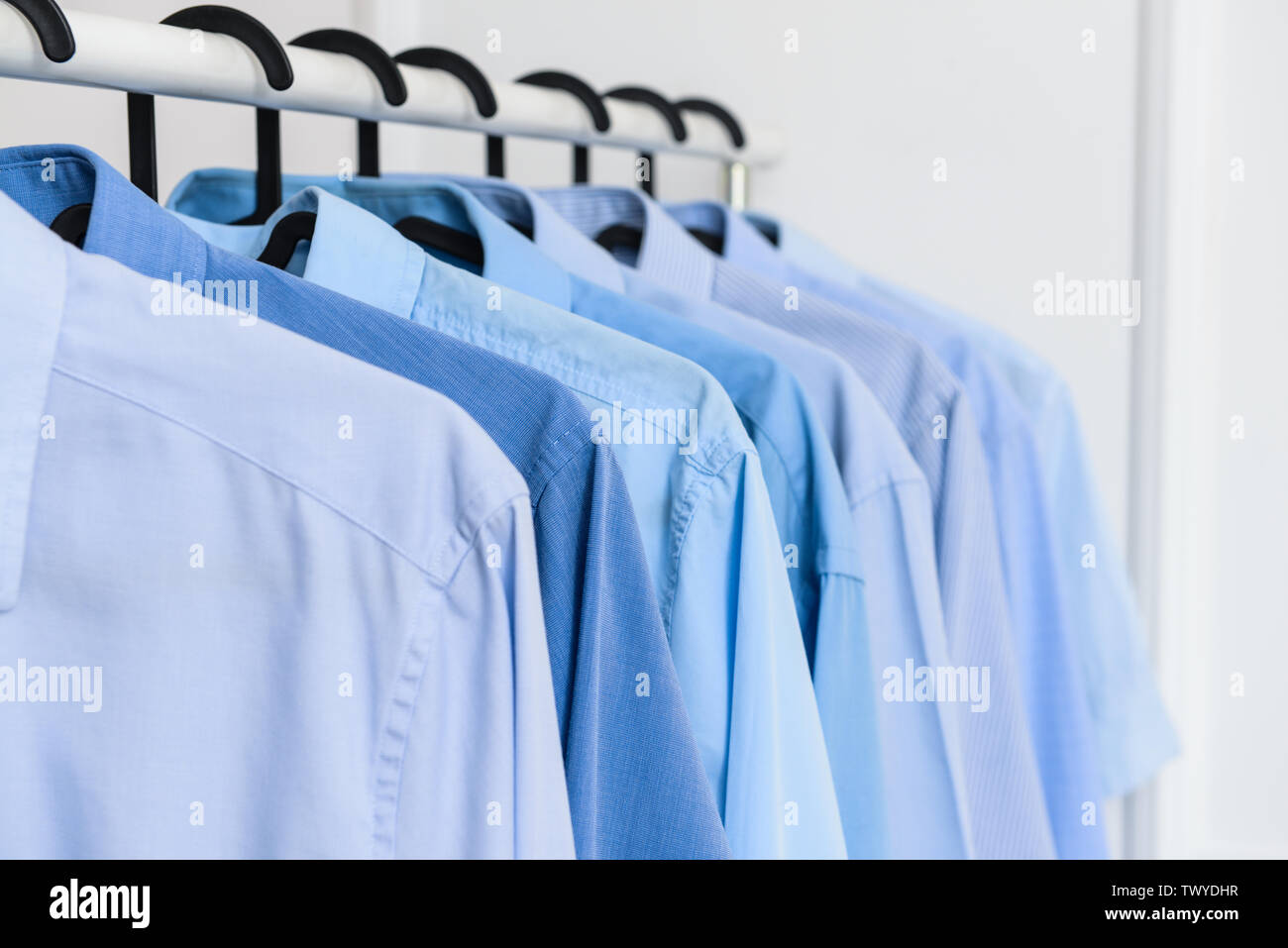 Rack with clothes after dry-cleaning near white wall, closeup Stock ...