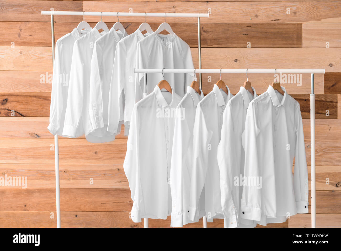 Racks with clothes after dry-cleaning on wooden background Stock Photo ...