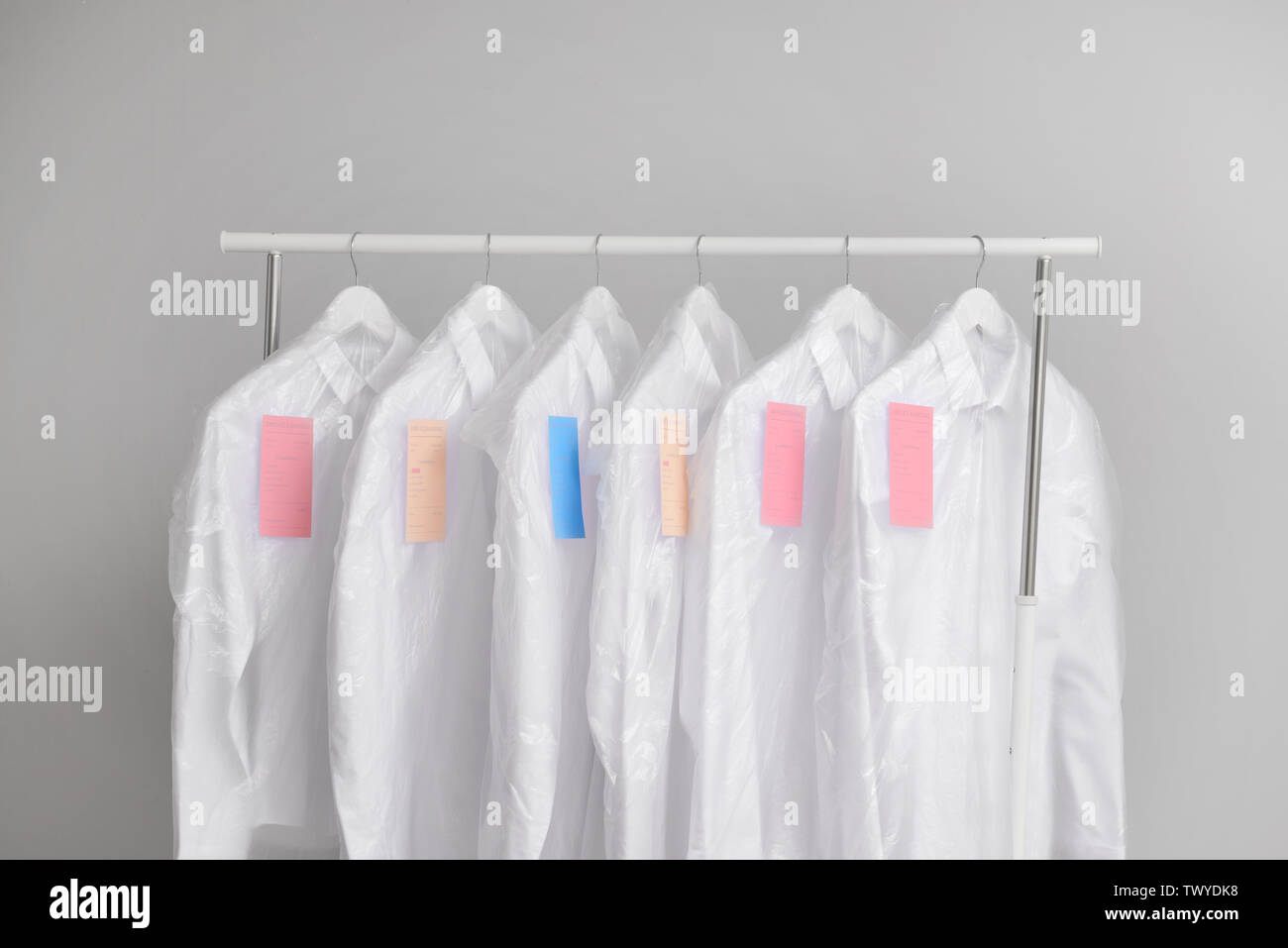 Rack with clothes after dry-cleaning on light background Stock Photo ...