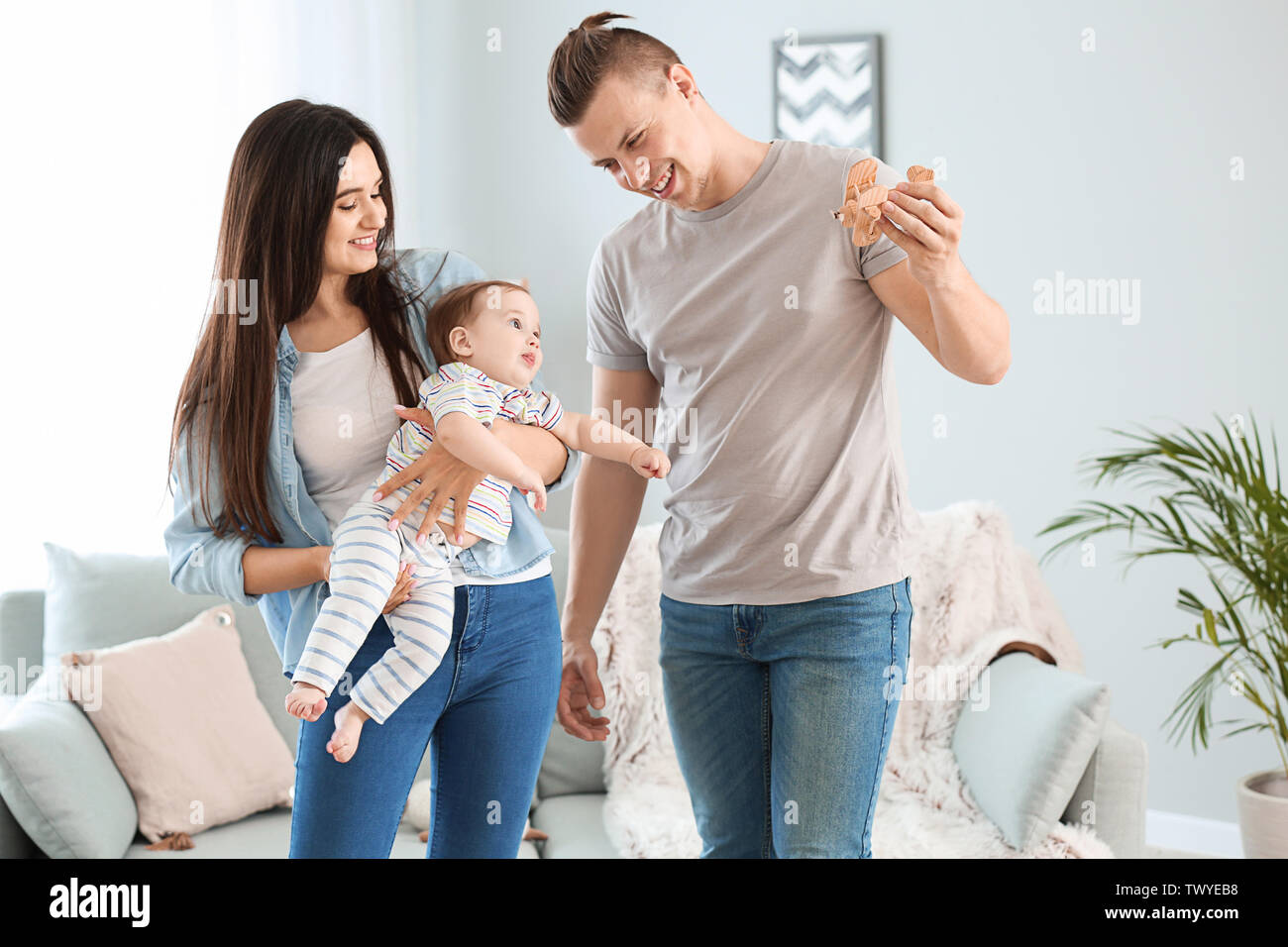 Happy parents with cute little baby at home Stock Photo - Alamy