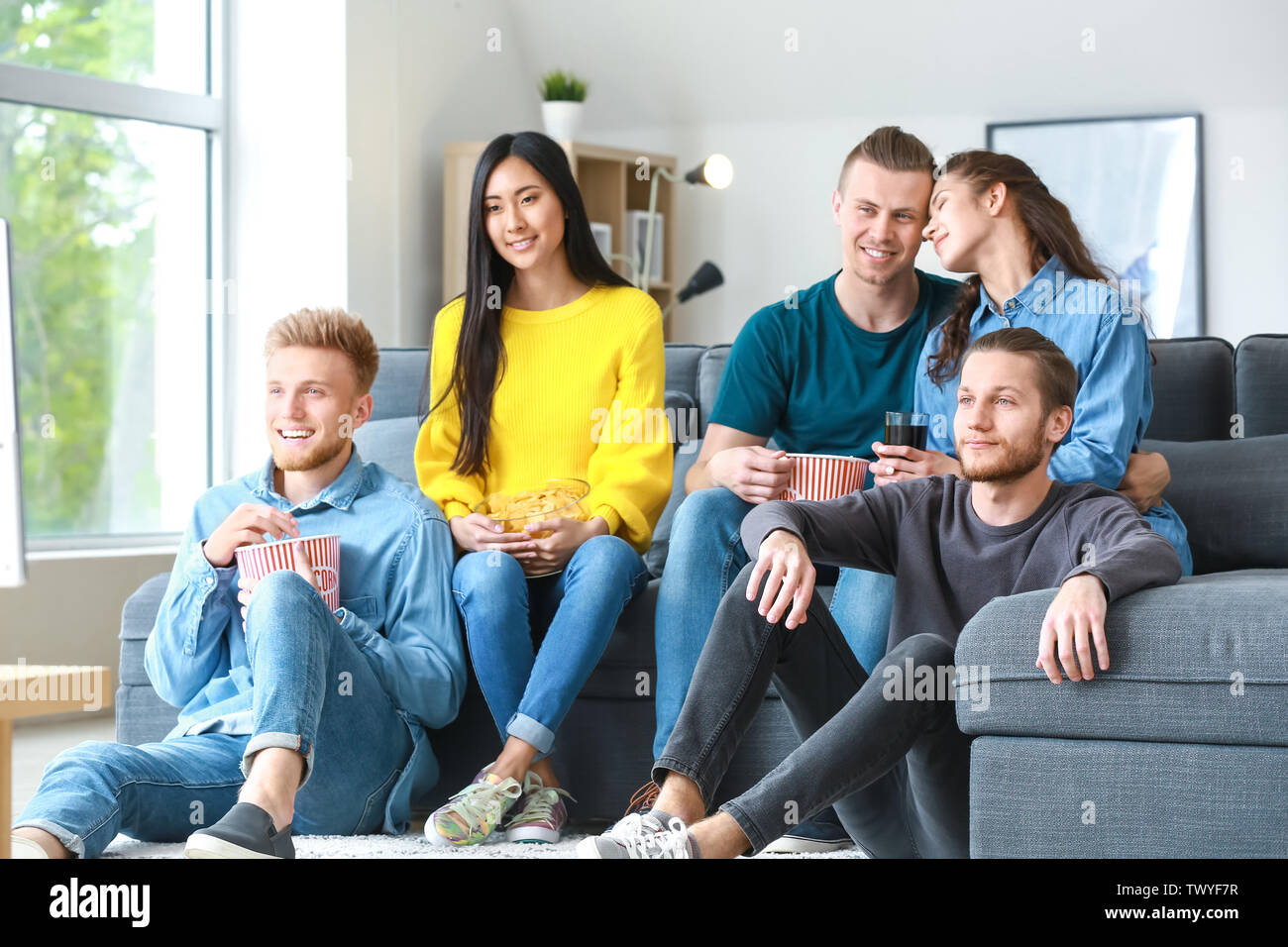 Friends watching TV at home Stock Photo - Alamy