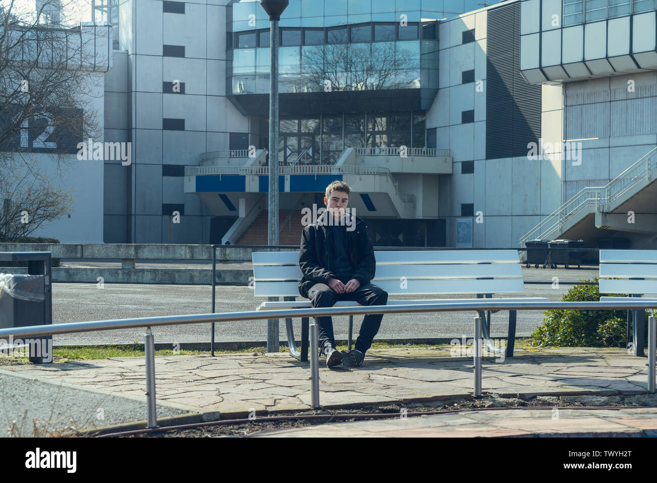portrait of a sad young man sitting on a bench Stock Photo - Alamy