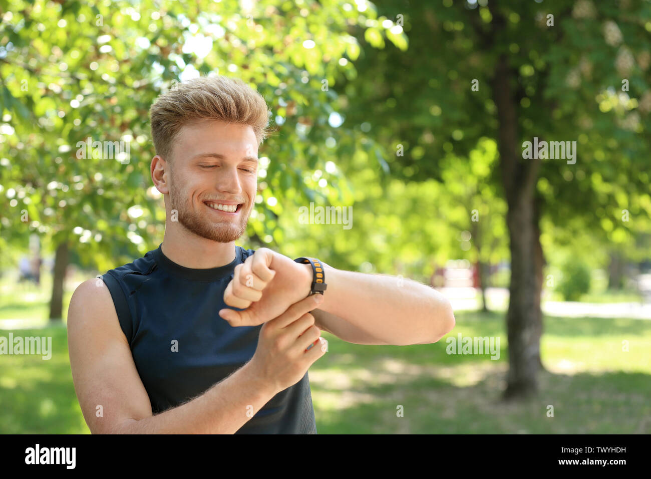 Sporty young man checking his pulse outdoors Stock Photo - Alamy