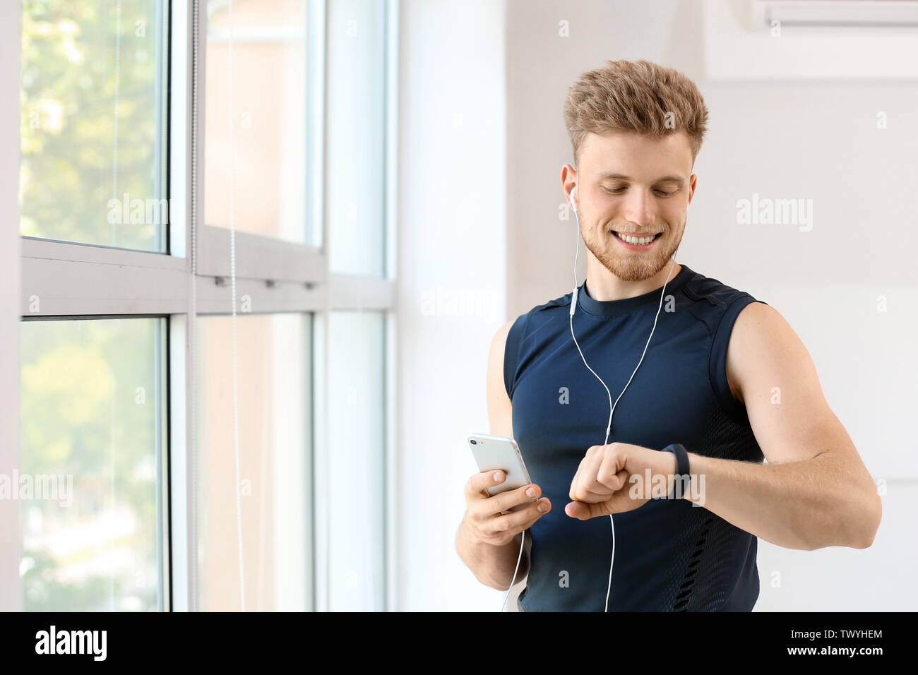 Sporty young man checking his pulse after training in gym Stock Photo ...