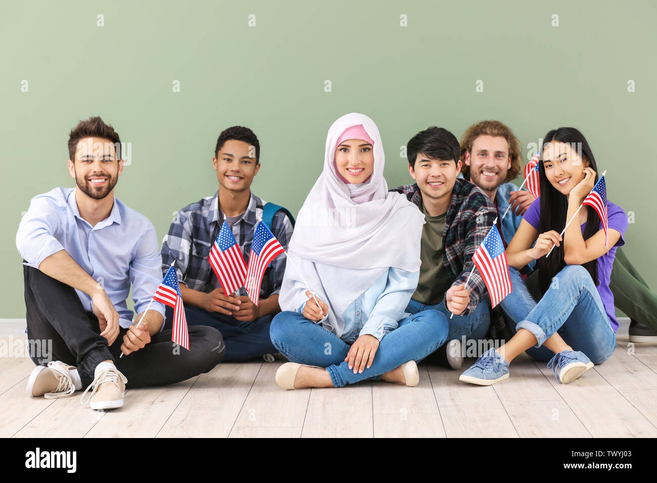 Group of students with USA flags sitting near color wall Stock Photo ...