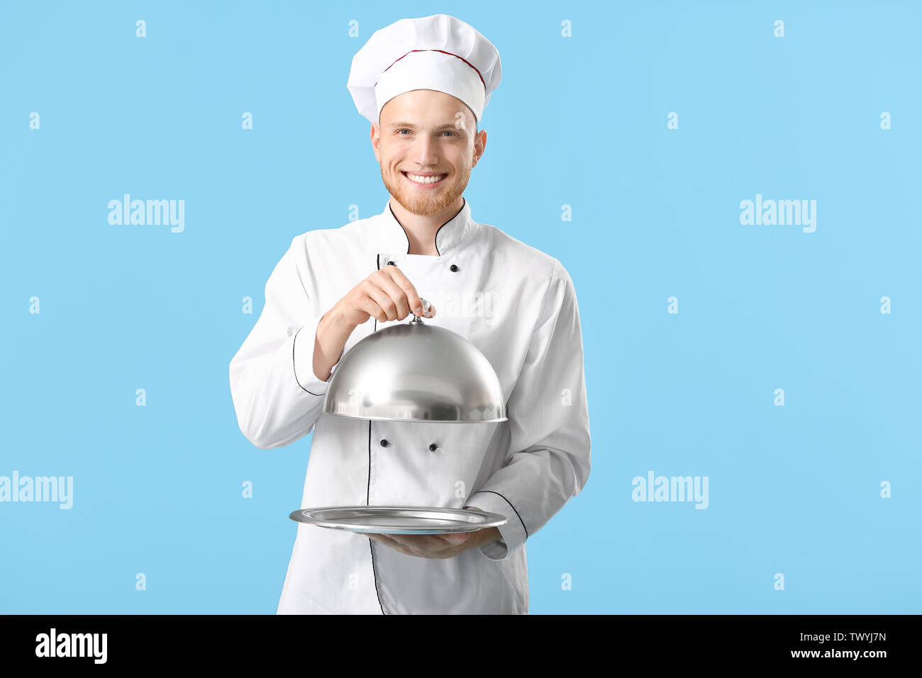 Handsome male chef with tray and cloche on color background Stock Photo ...