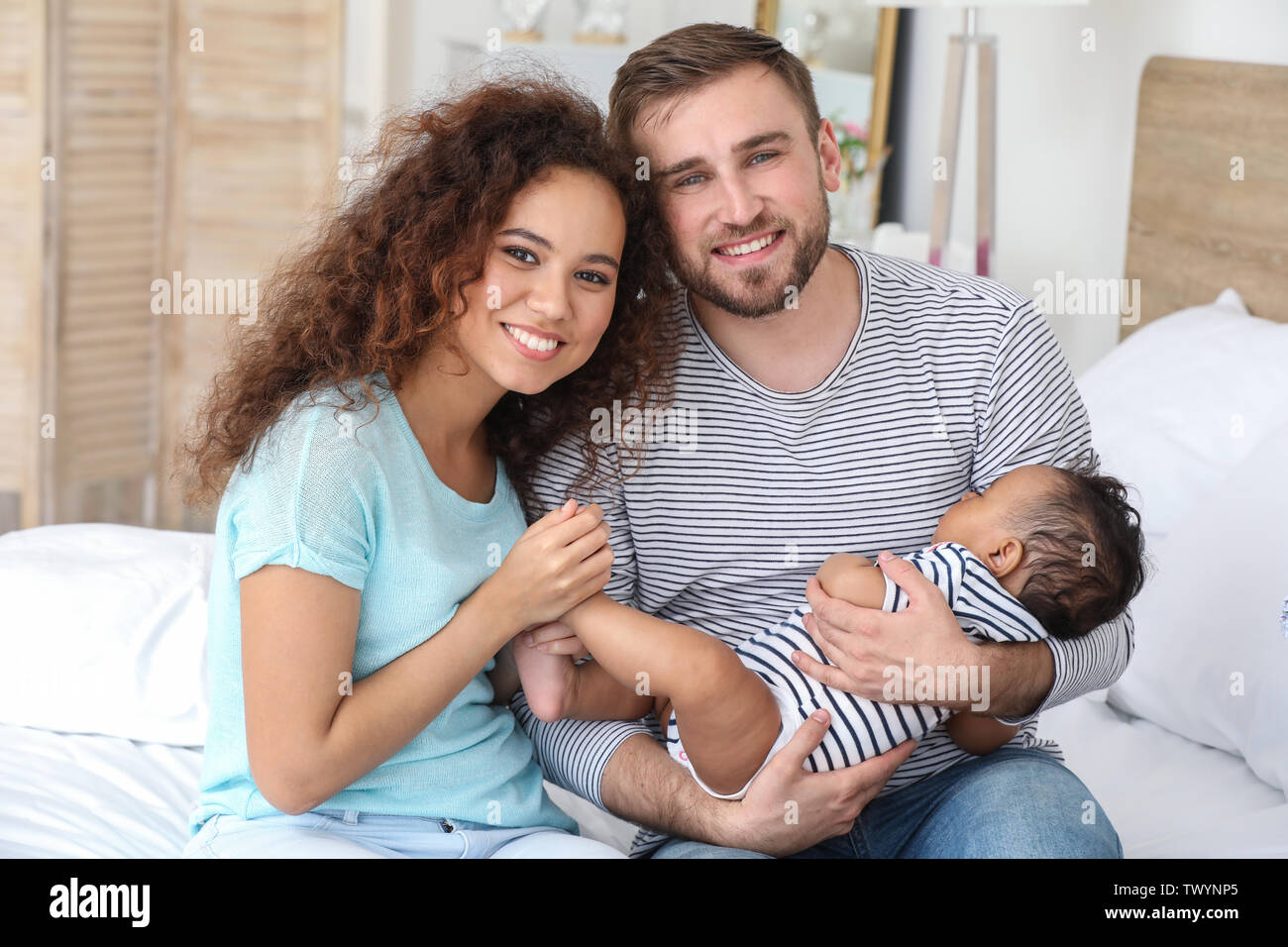 Portrait of happy interracial family in bedroom Stock Photo - Alamy