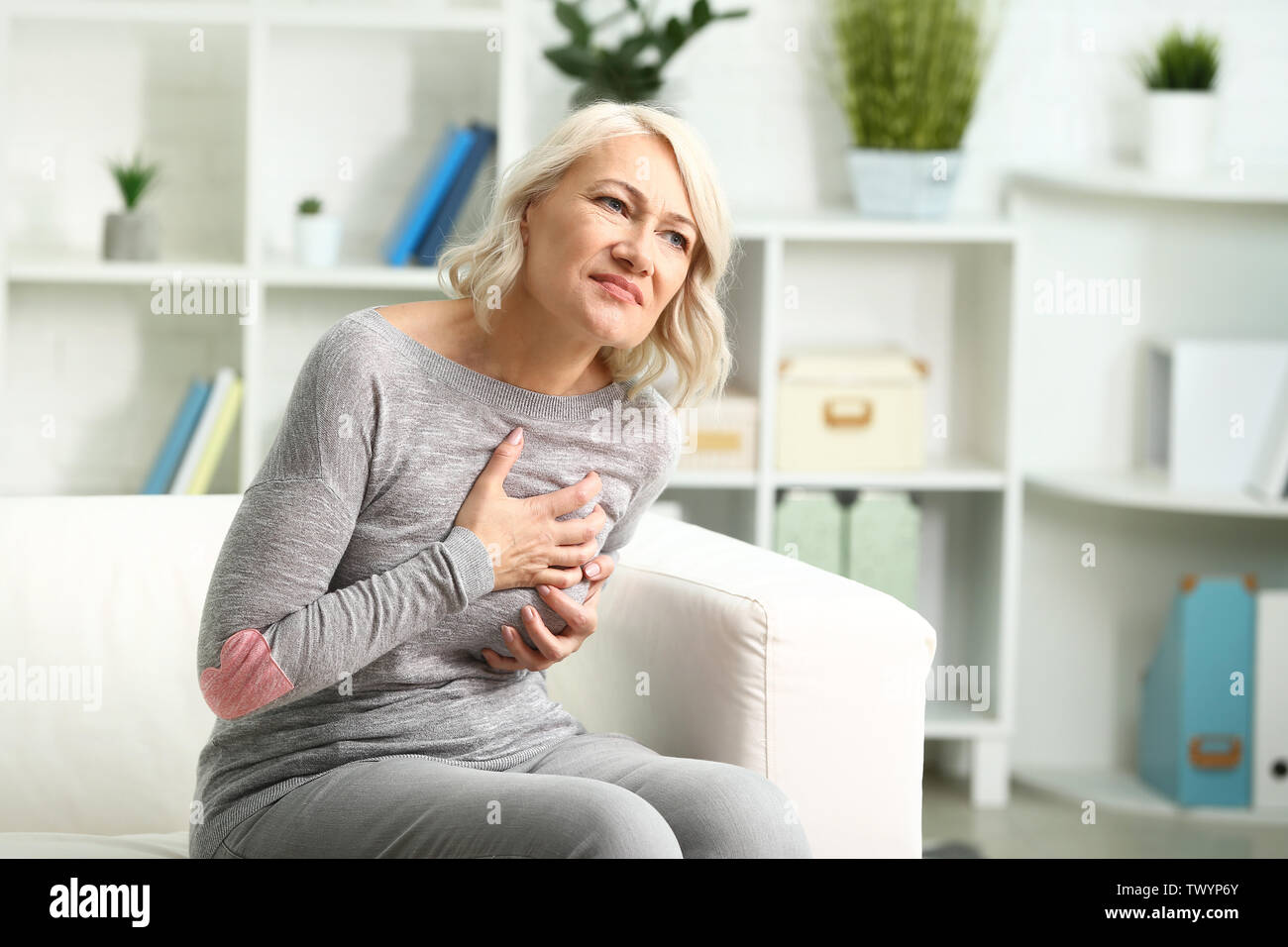 Heart attack aged female sitting hi-res stock photography and images ...
