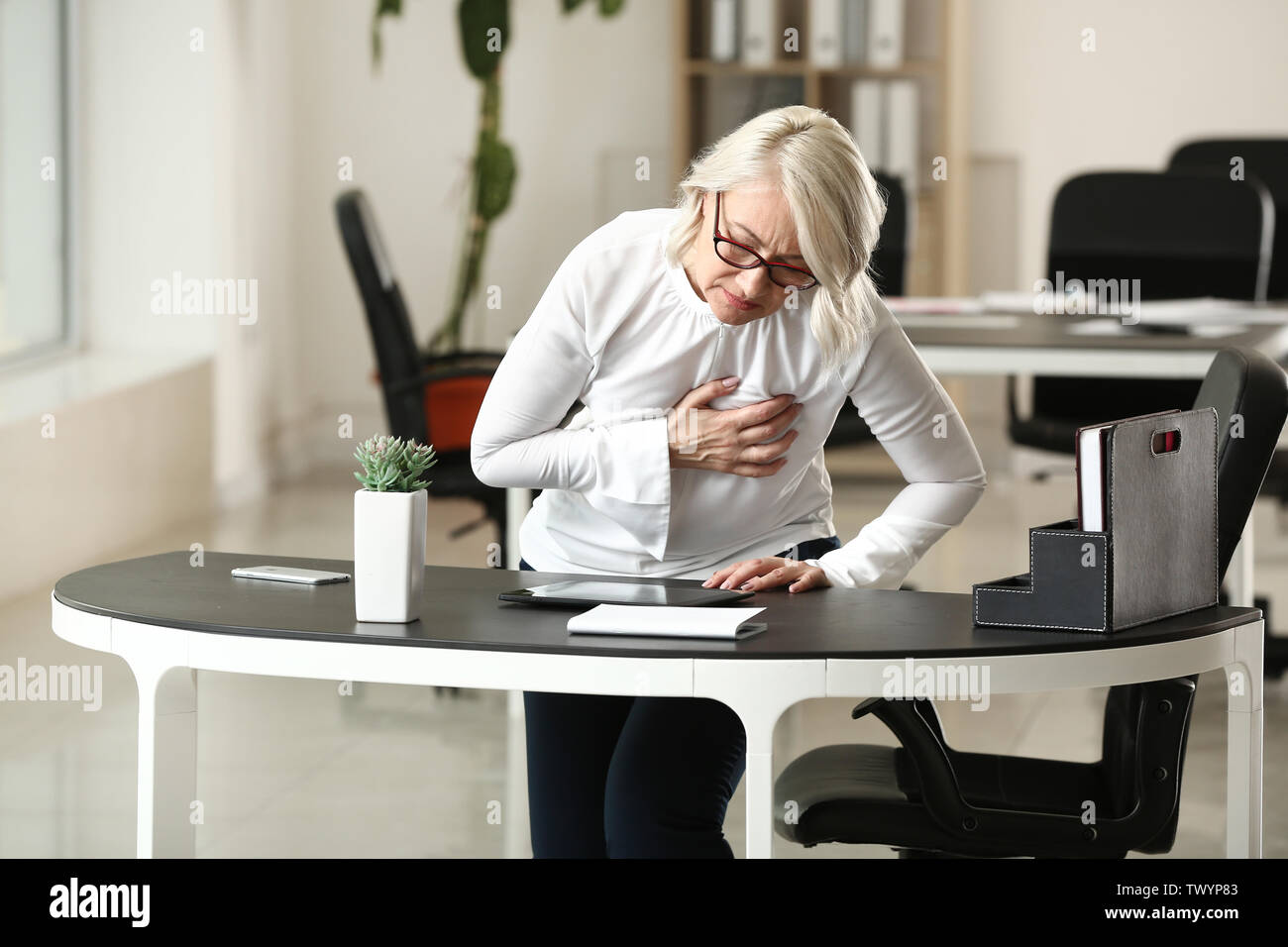 Heart attack aged female sitting hi-res stock photography and images ...
