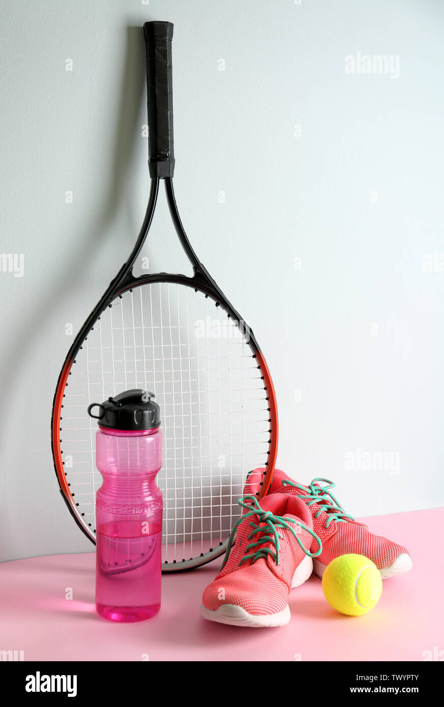 Tennis racket, ball, bottle of water and shoes on light background ...