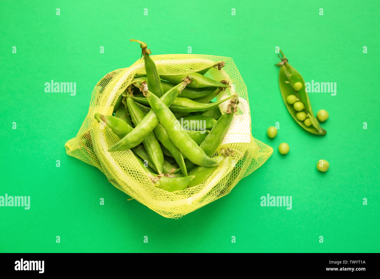 Eco bag with peas on color background Stock Photo - Alamy