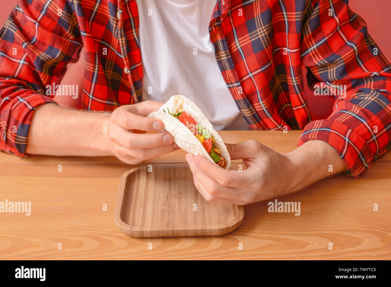 Man eating tasty taco at table, closeup Stock Photo - Alamy