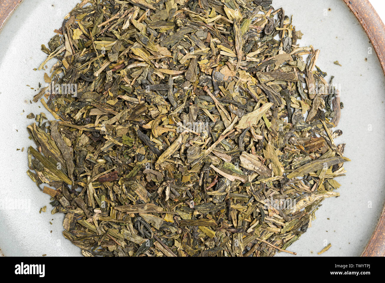 A studio product shot of a bunch of dried Chinese green tea leaves on ...