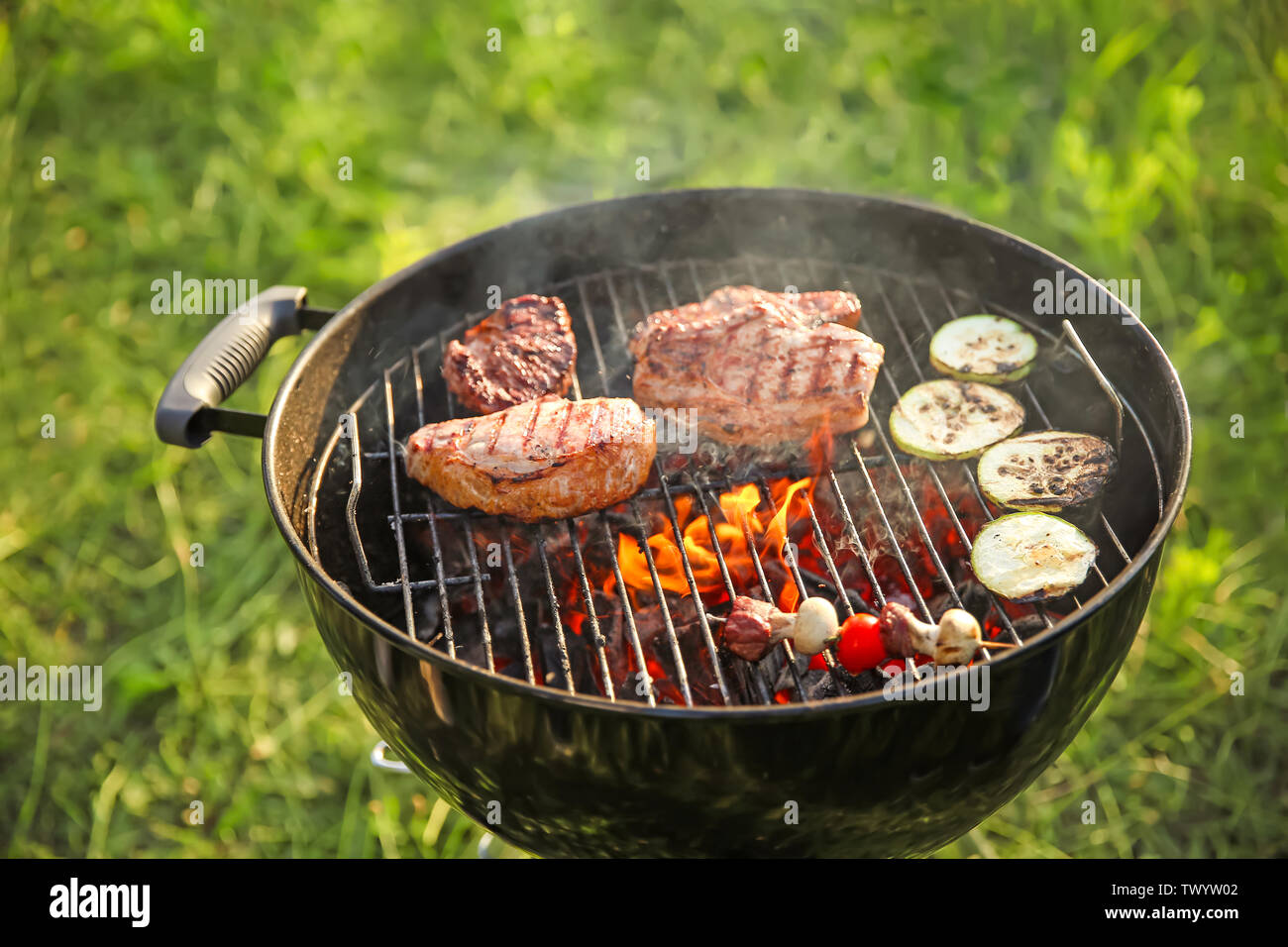 Cooking of tasty food on barbecue grill outdoors Stock Photo - Alamy