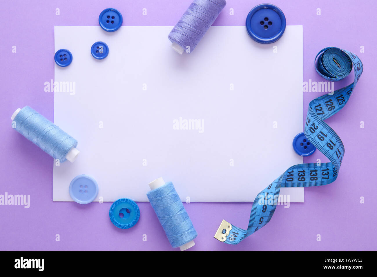 Set of sewing threads with accessories and sheet of paper on color ...
