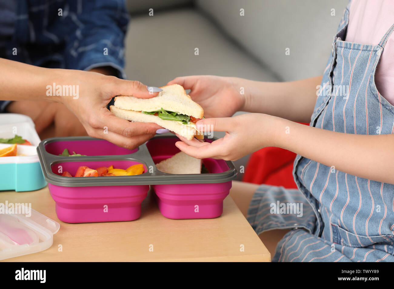 Mother packing school lunch for her little daughter at home Stock Photo ...