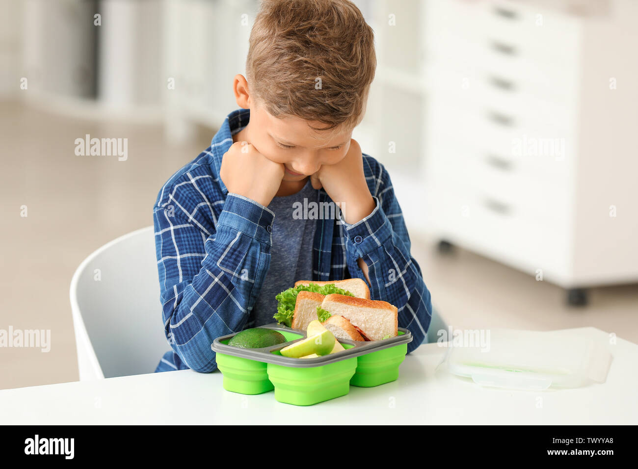 Little schoolboy with tasty lunch in box in classroom Stock Photo - Alamy