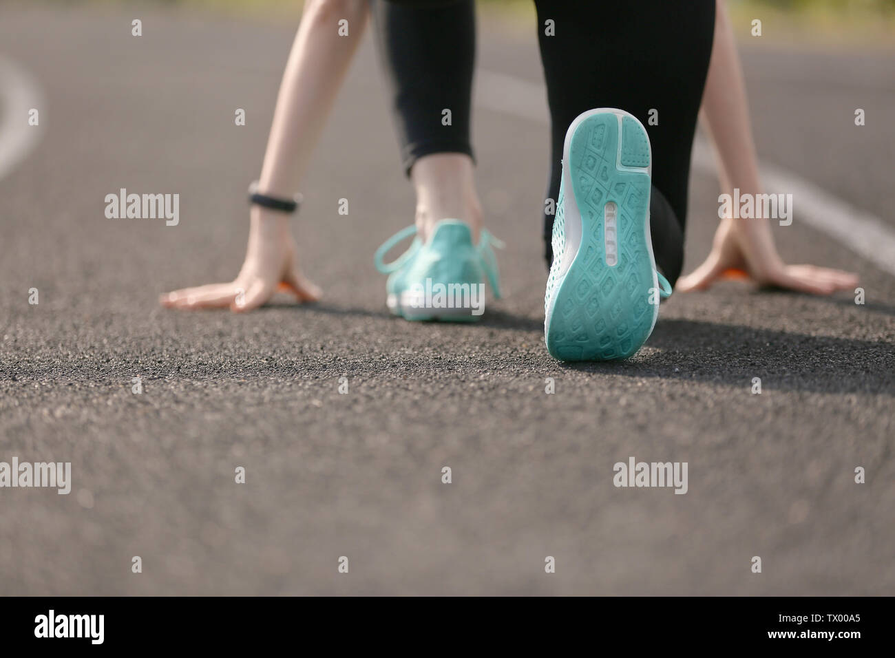 Sporty young woman in crouch start position at the stadium Stock Photo ...