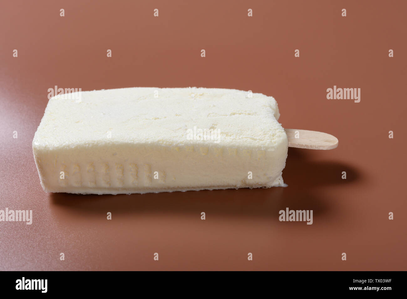 side view fresh milkshake flavor popsicle on a brown background with ...