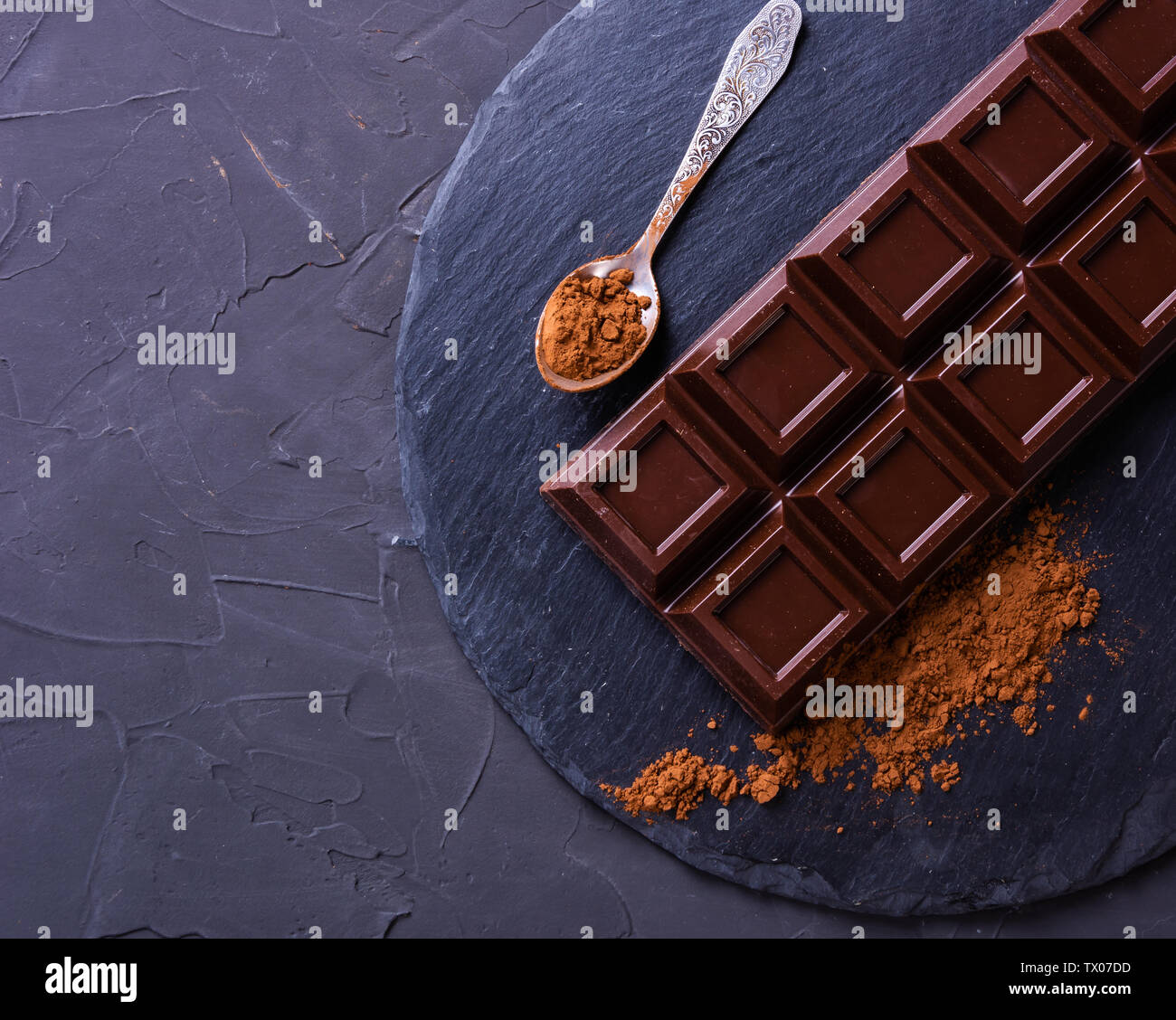 Chocolate bar with cocoas on grey background Stock Photo - Alamy