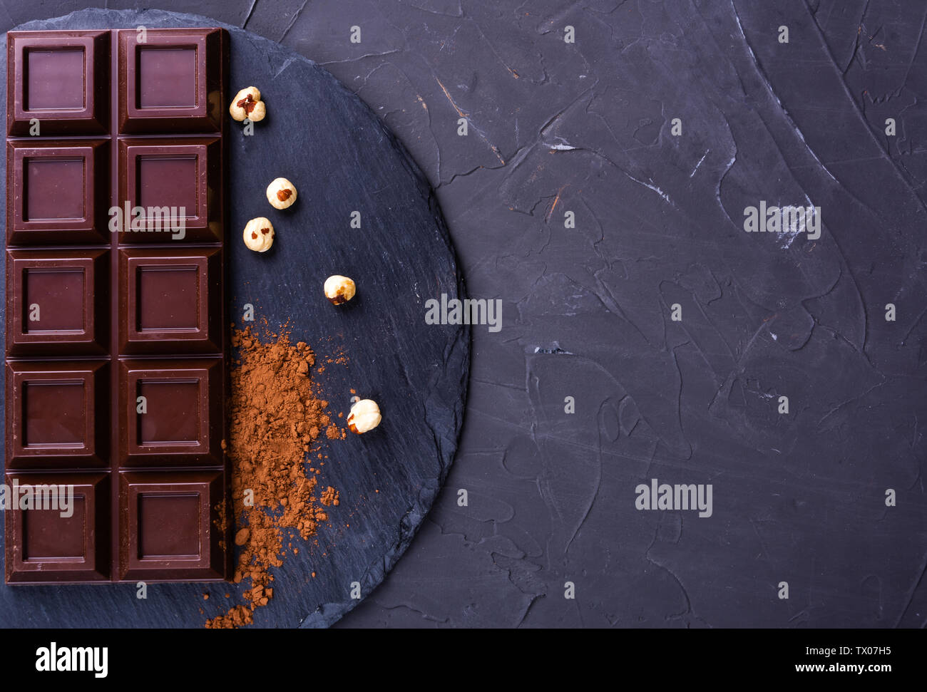 Chocolate bar with cocoas on grey background Stock Photo - Alamy