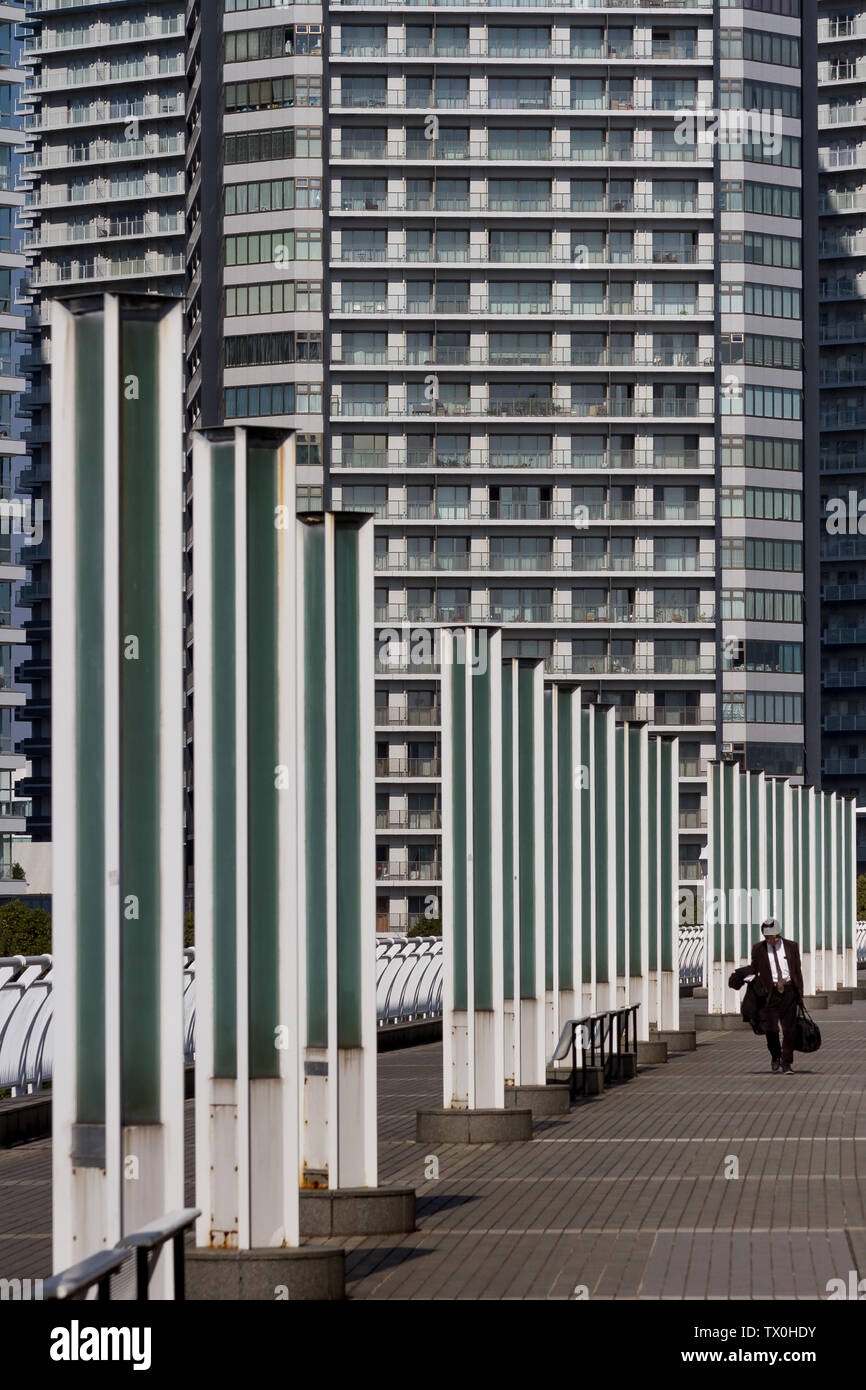 A salaryman or Japanese office worker walks in front of apartment ...