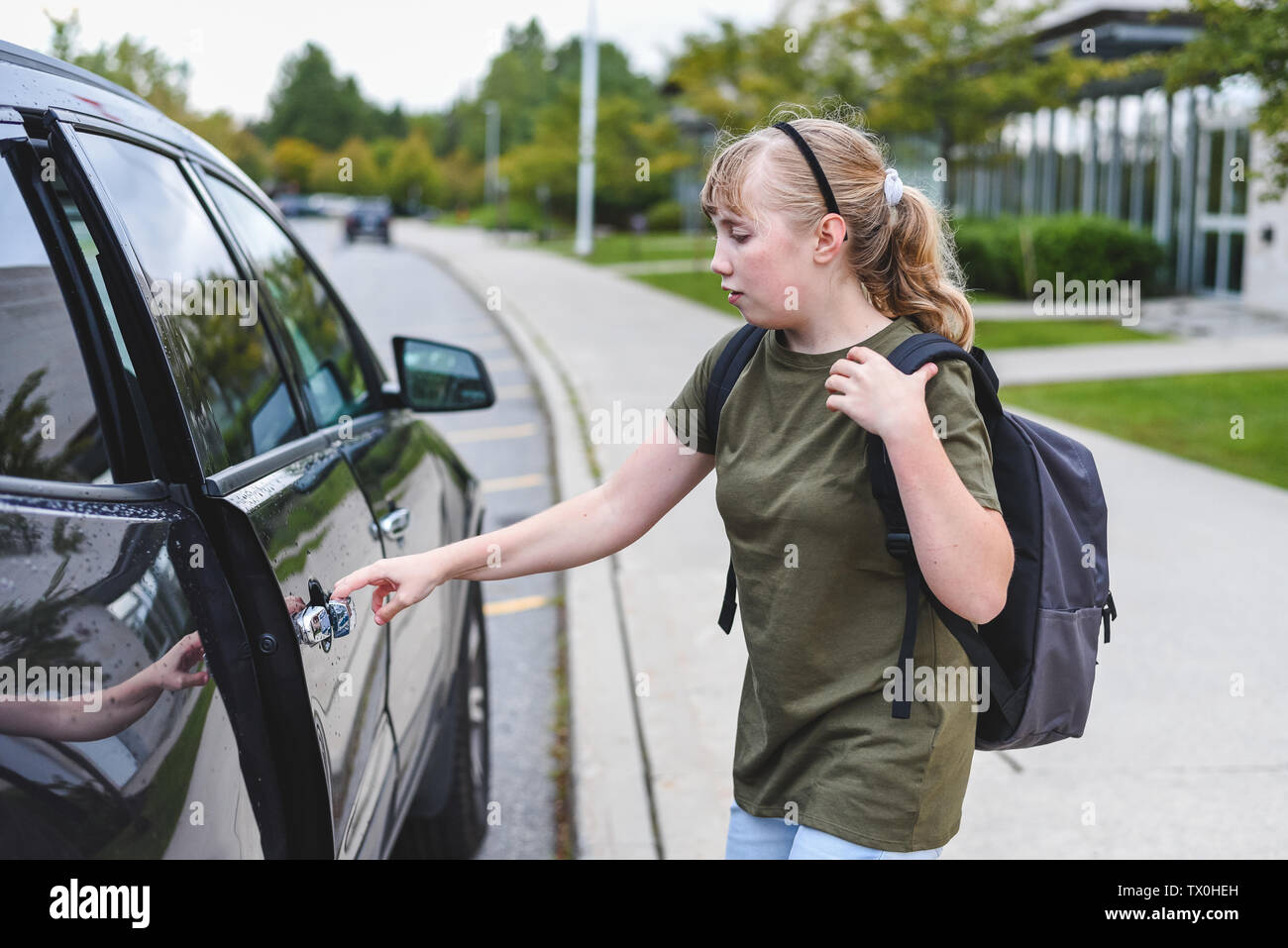 Teenage girl being picked up from school by parents Stock Photo - Alamy