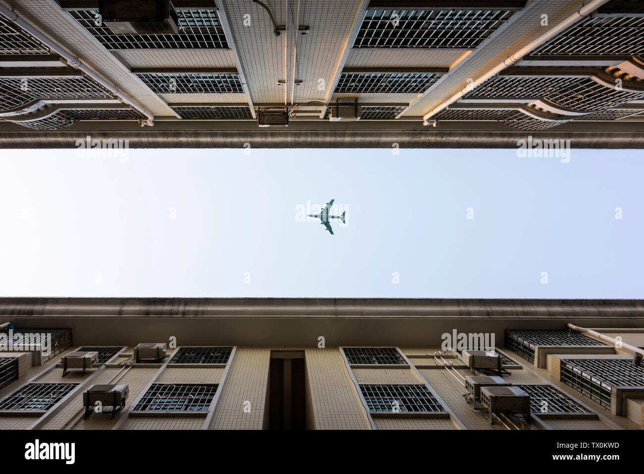 A plane flew through the sky between two buildings Stock Photo - Alamy