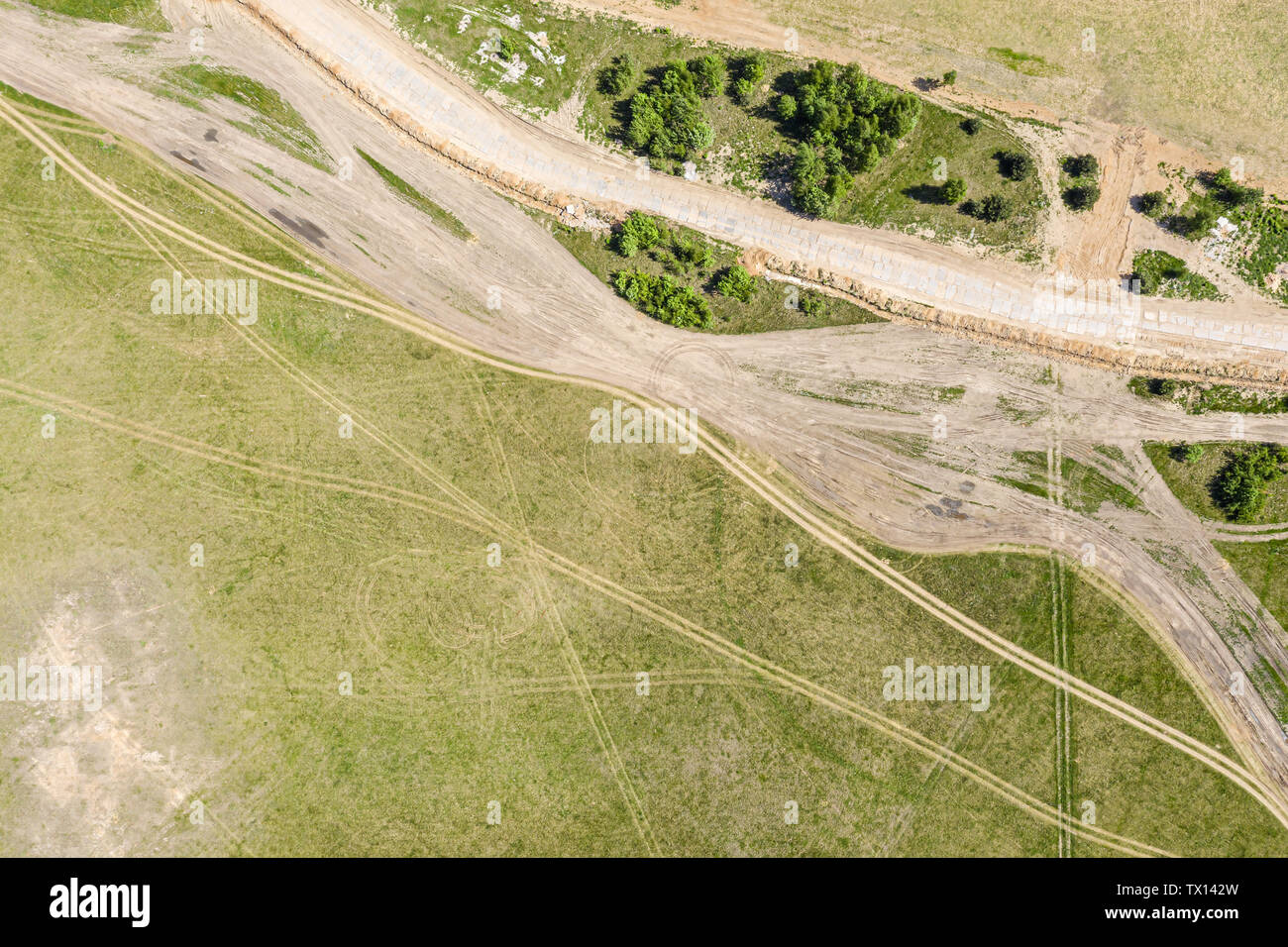 aerial view of off-road racing tracks running through a green field ...