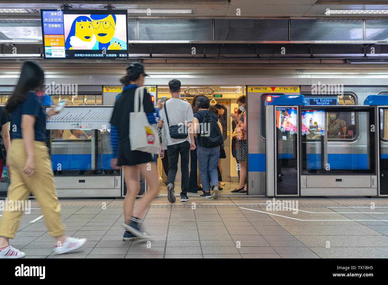 Taipei metro station hall and platform. Subway passengers walk through ...