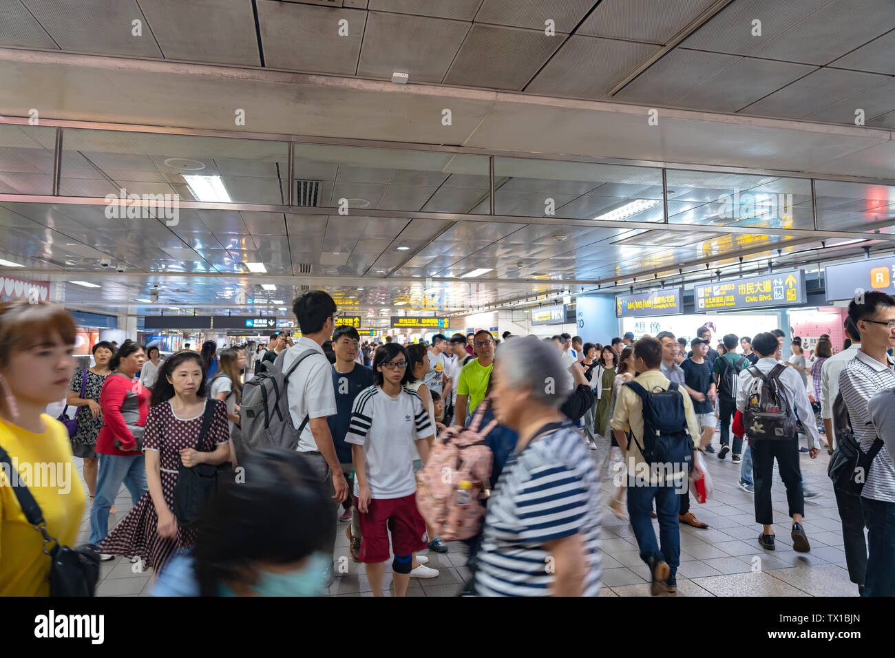 Taipei metro station hall and platform. Subway passengers walk through ...
