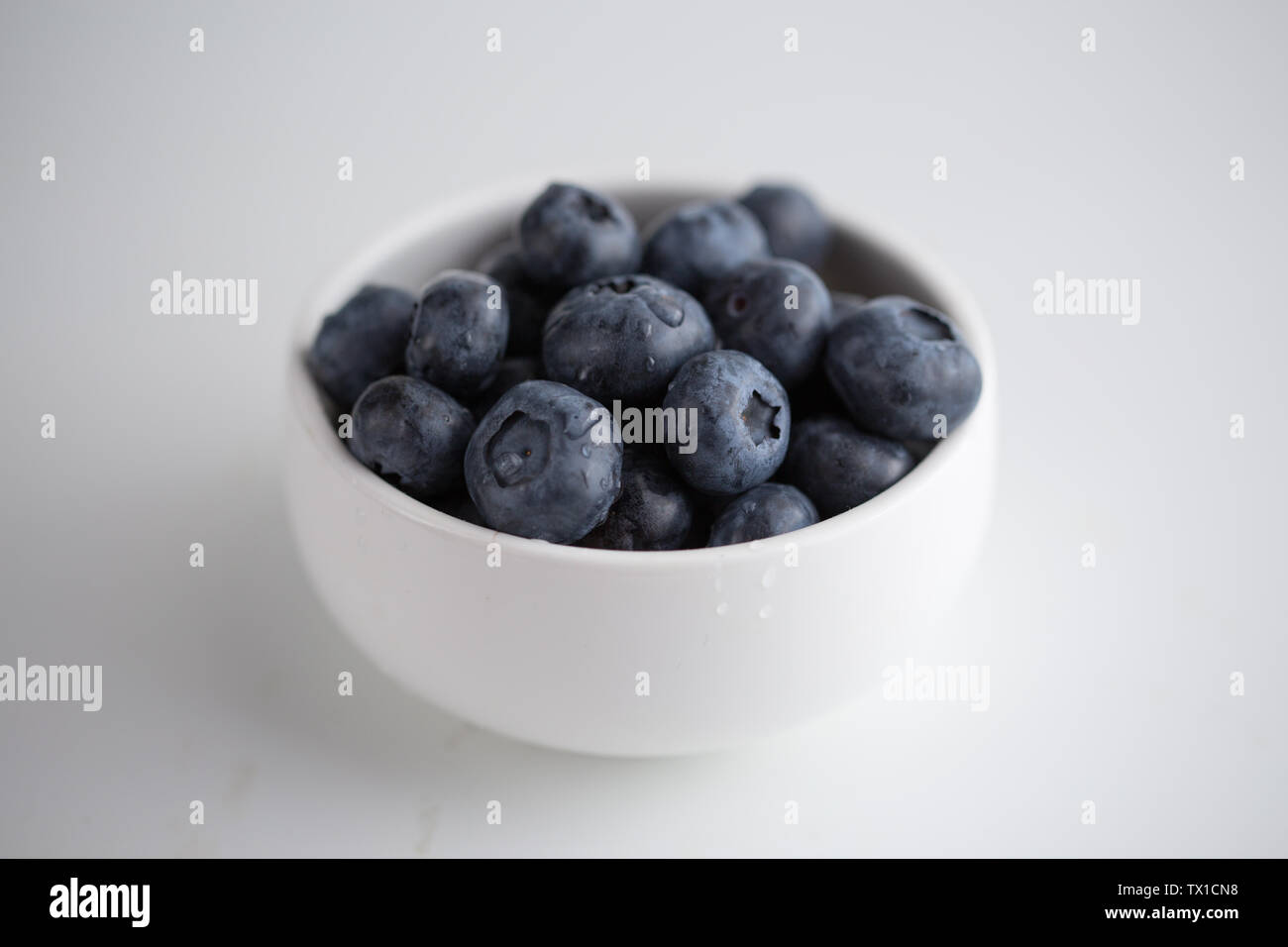 Blueberries in a white ceramic bowl inside a white background Stock ...