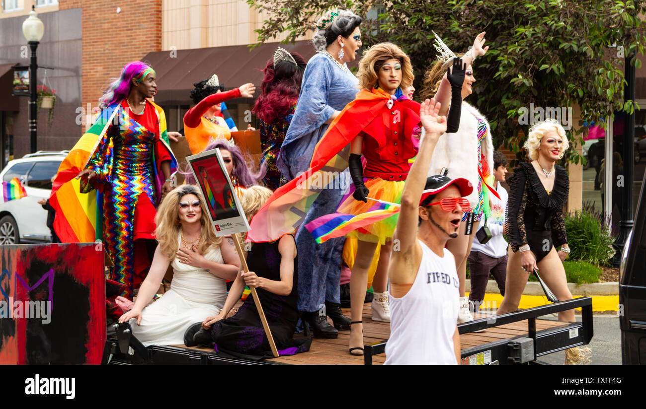 A float of drag queens wearing rainbow colors, showing their expressive ...