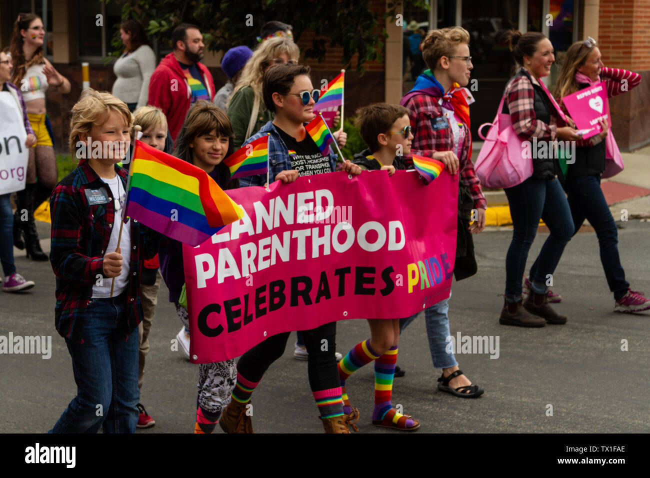 Kids march with Rainbow flags and holding a sign the states Planned ...