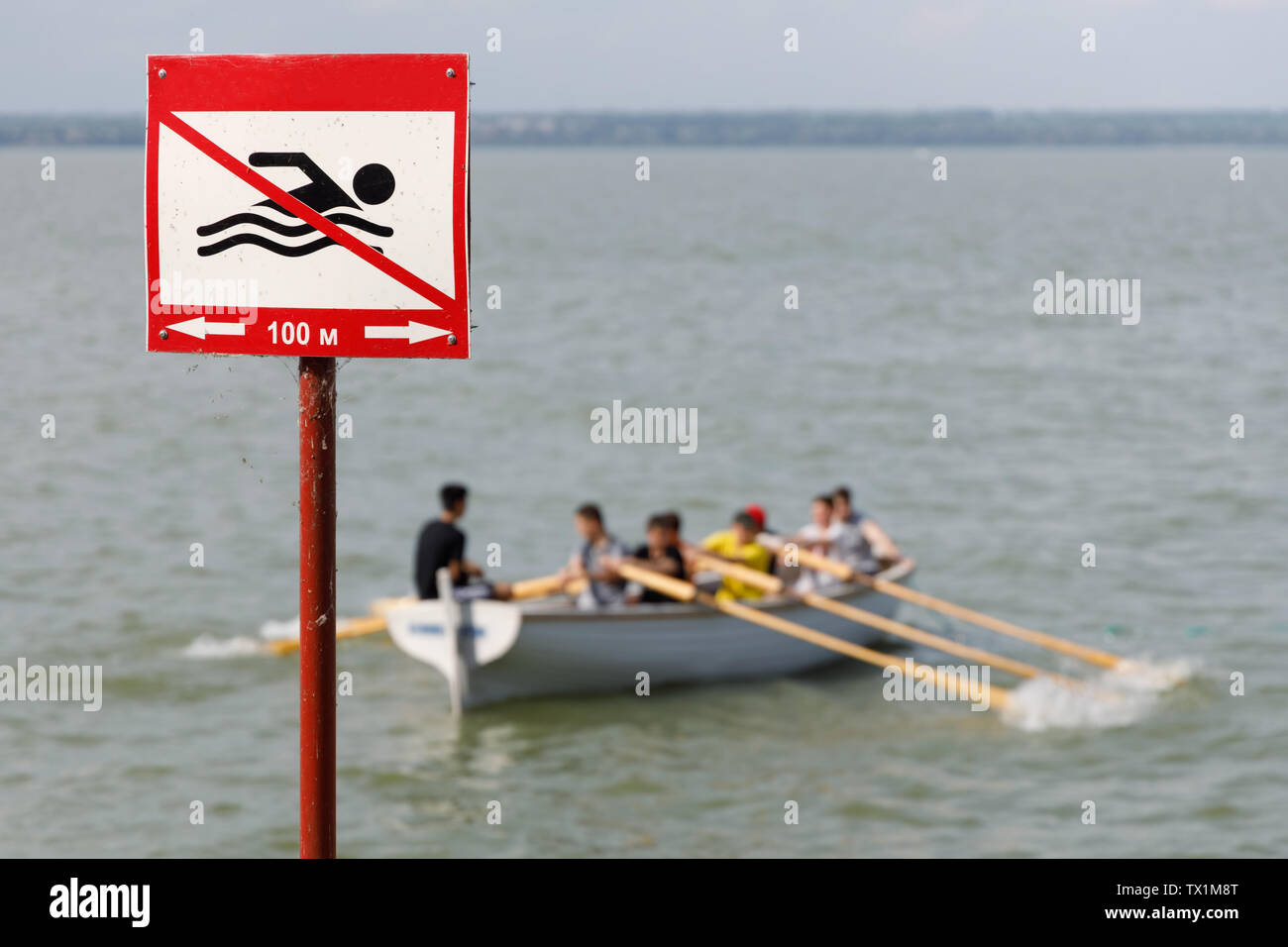 Sign prohibiting swimming in this place on the background of a wooden ...