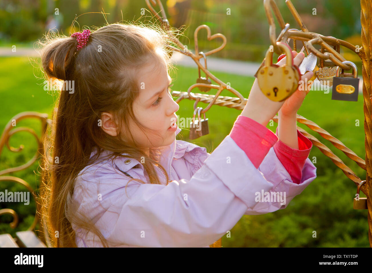 The little girl is holding an iron lock Stock Photo - Alamy