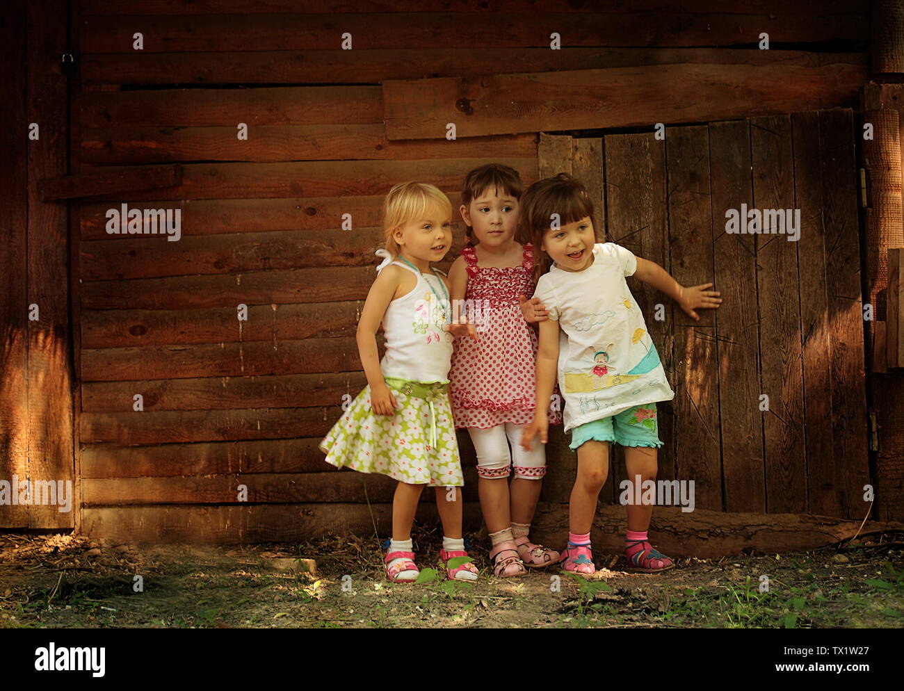 Three little girls playing near the wooden house in the park Stock ...