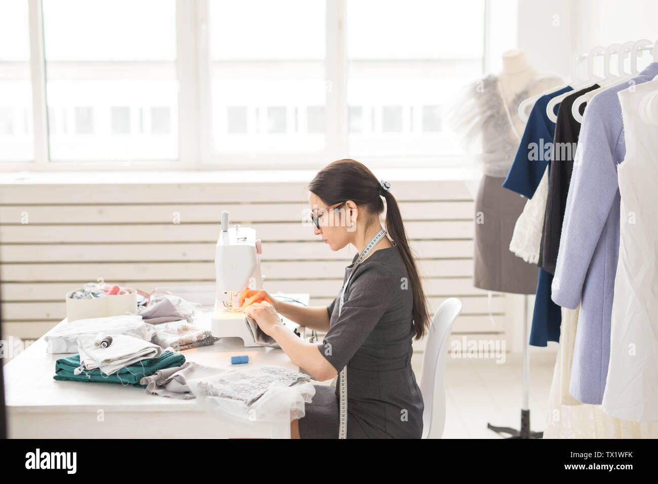 people, dressmaker, tailor, fashion and showroom concept - young ...