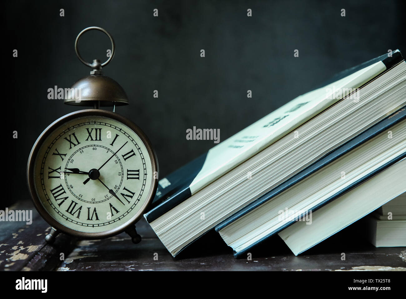 Books and alarm clocks cherish time reading time Stock Photo - Alamy