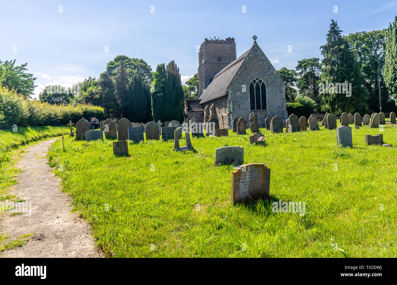 A view of All Saints Church, a traditional flint and thatched church in ...