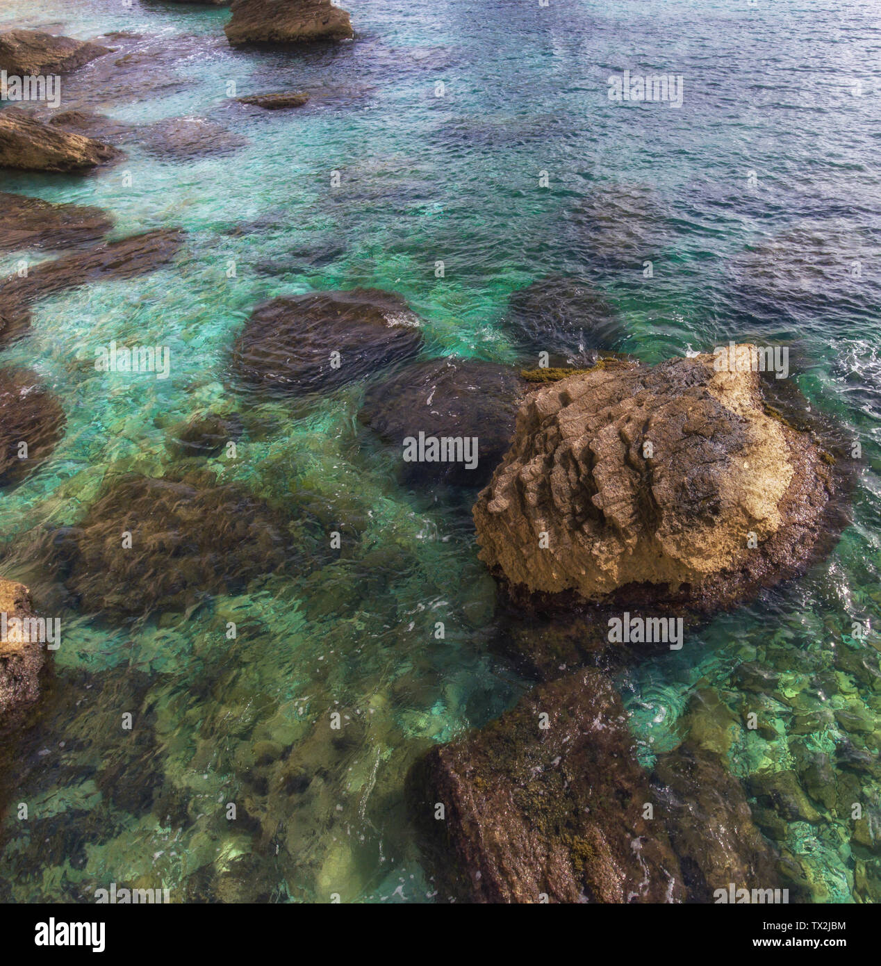 Pieces of rock in the sea in shallow water near the shore Stock Photo ...